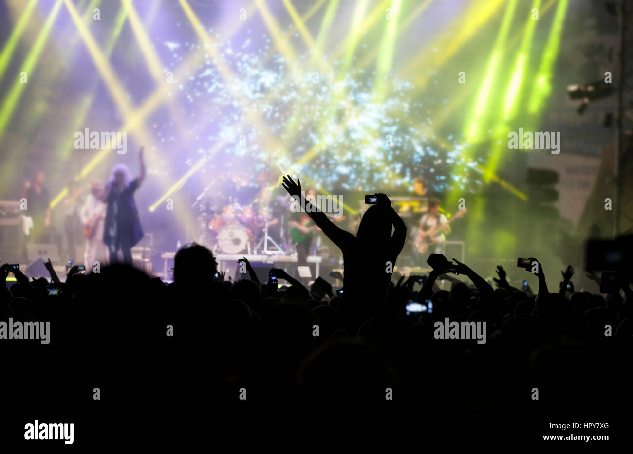 Photo of many people enjoying rock concert, crowd with raised up hands ...