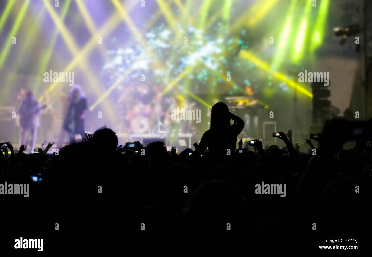 Photo of many people enjoying rock concert, crowd with raised up hands ...