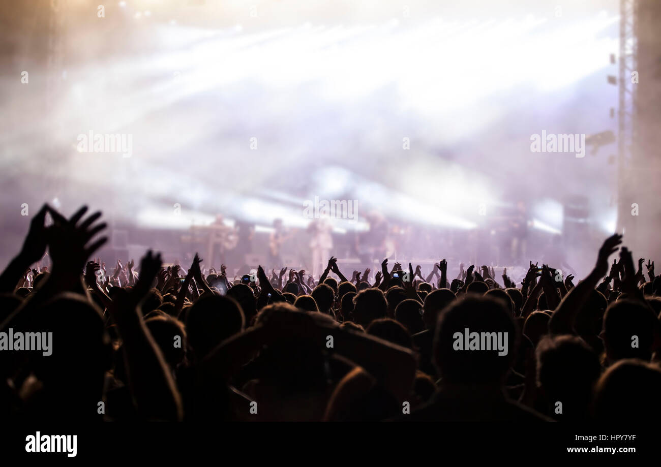 Photo of many people enjoying rock concert, crowd with raised up hands ...