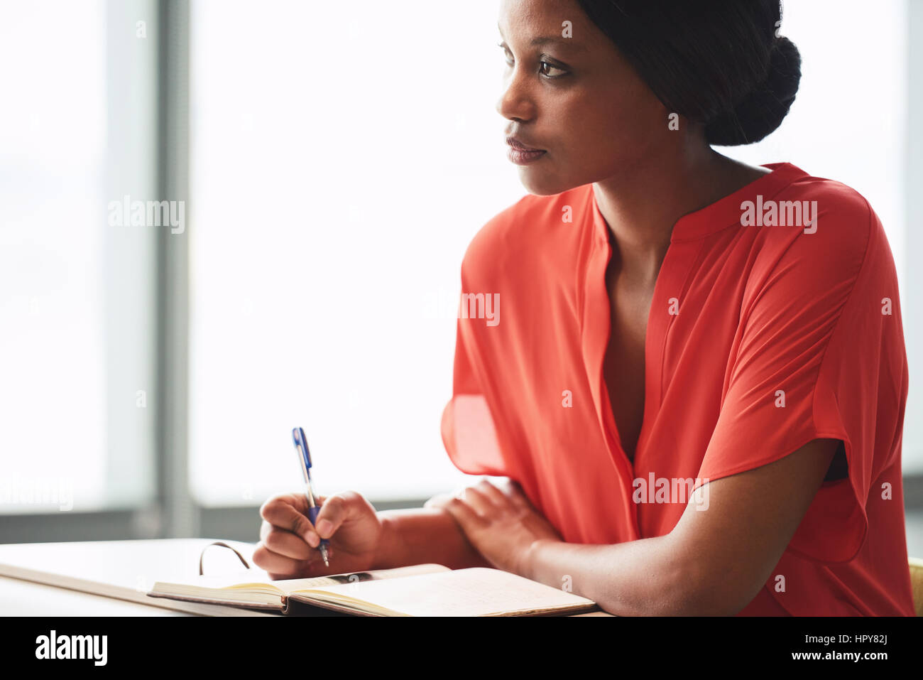 Black female creative writer busy looking up into the distance as she ...