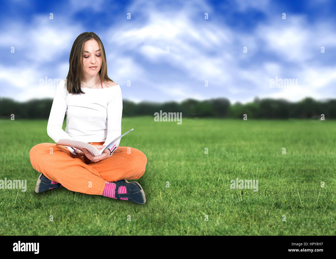beautiful girl reading on the grass in a park Stock Photo - Alamy