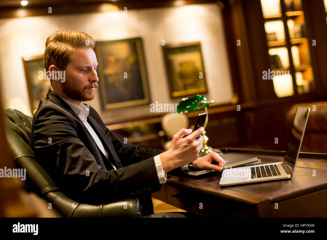 Young man working in the room with vintage furniture Stock Photo - Alamy
