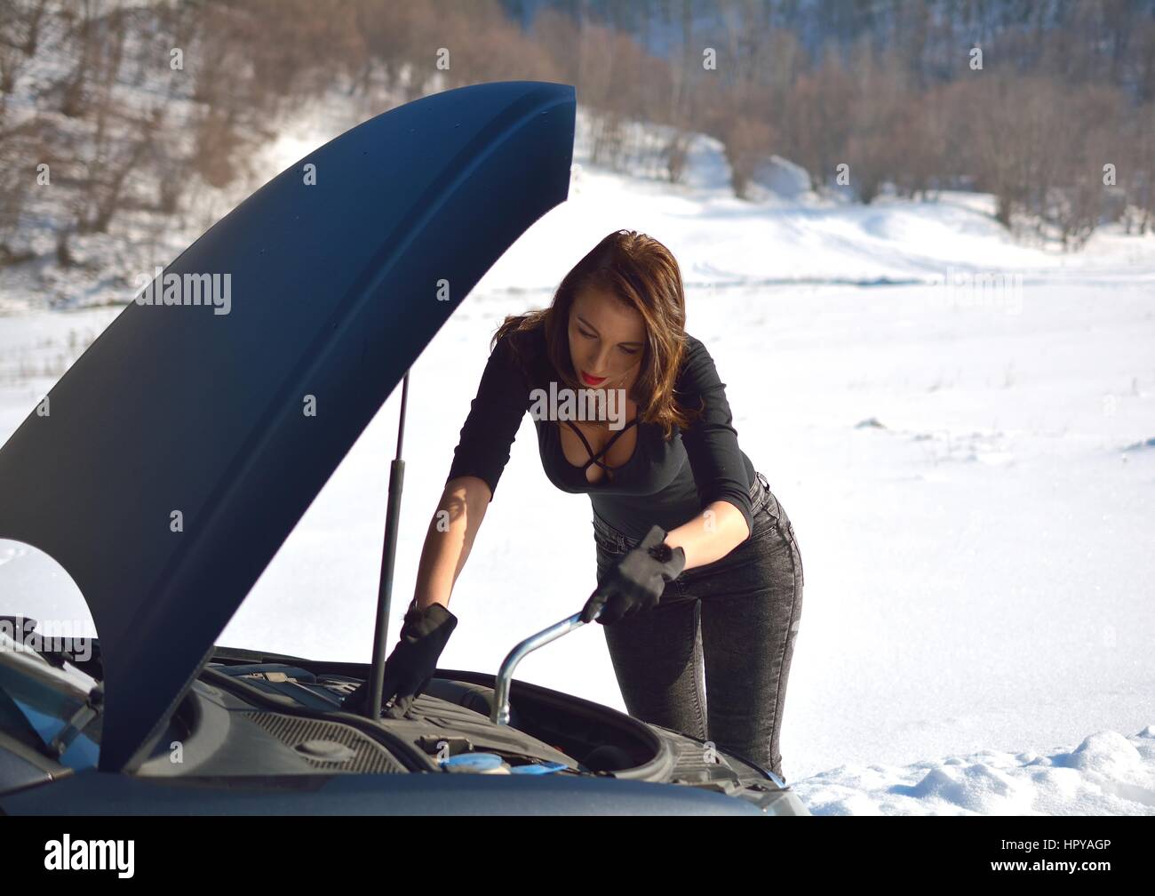 Winter car breakdown - young fashion woman trying to fix the car Stock ...