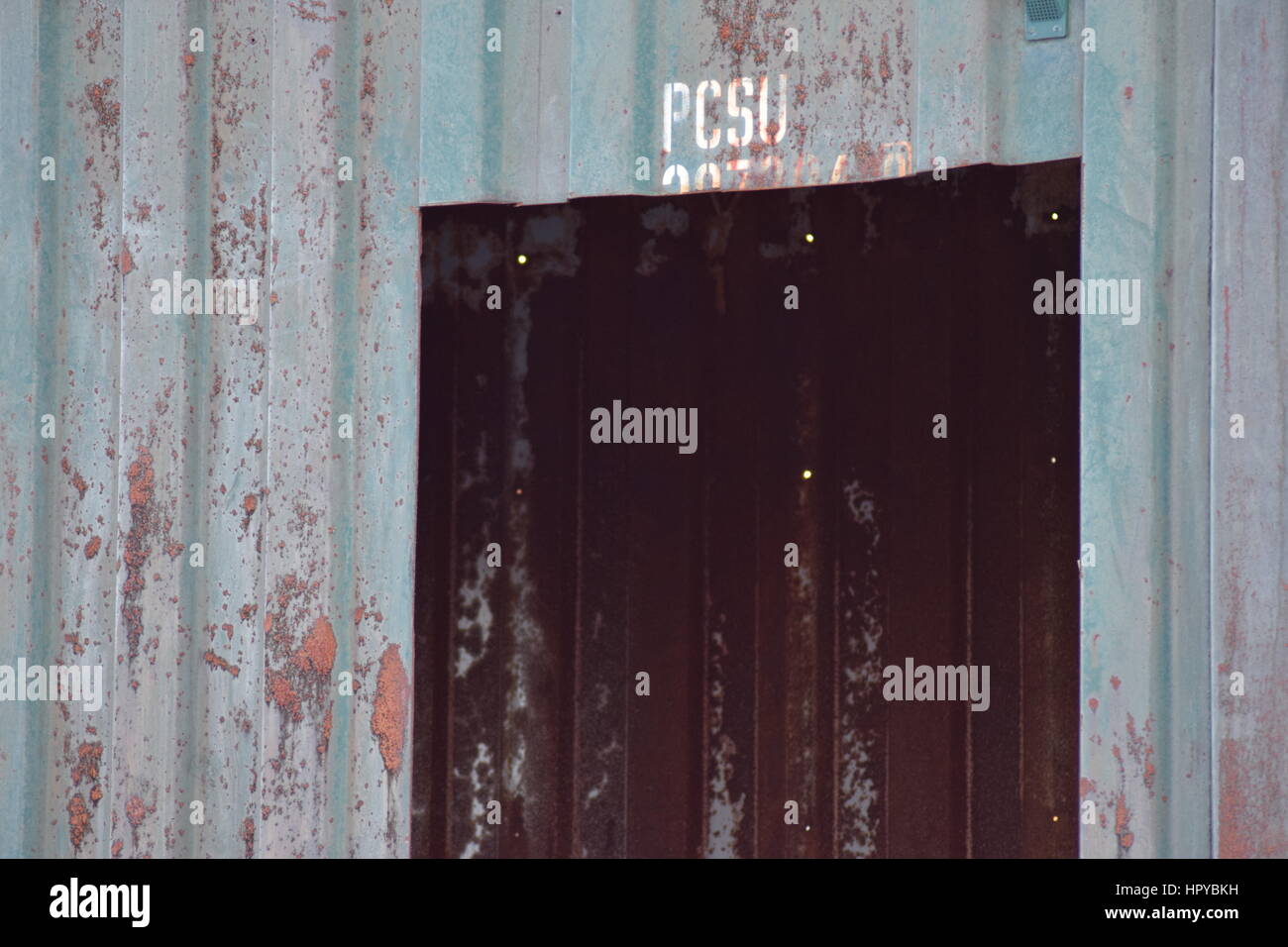 Rusty cargo container with square cut out as a door Stock Photo - Alamy