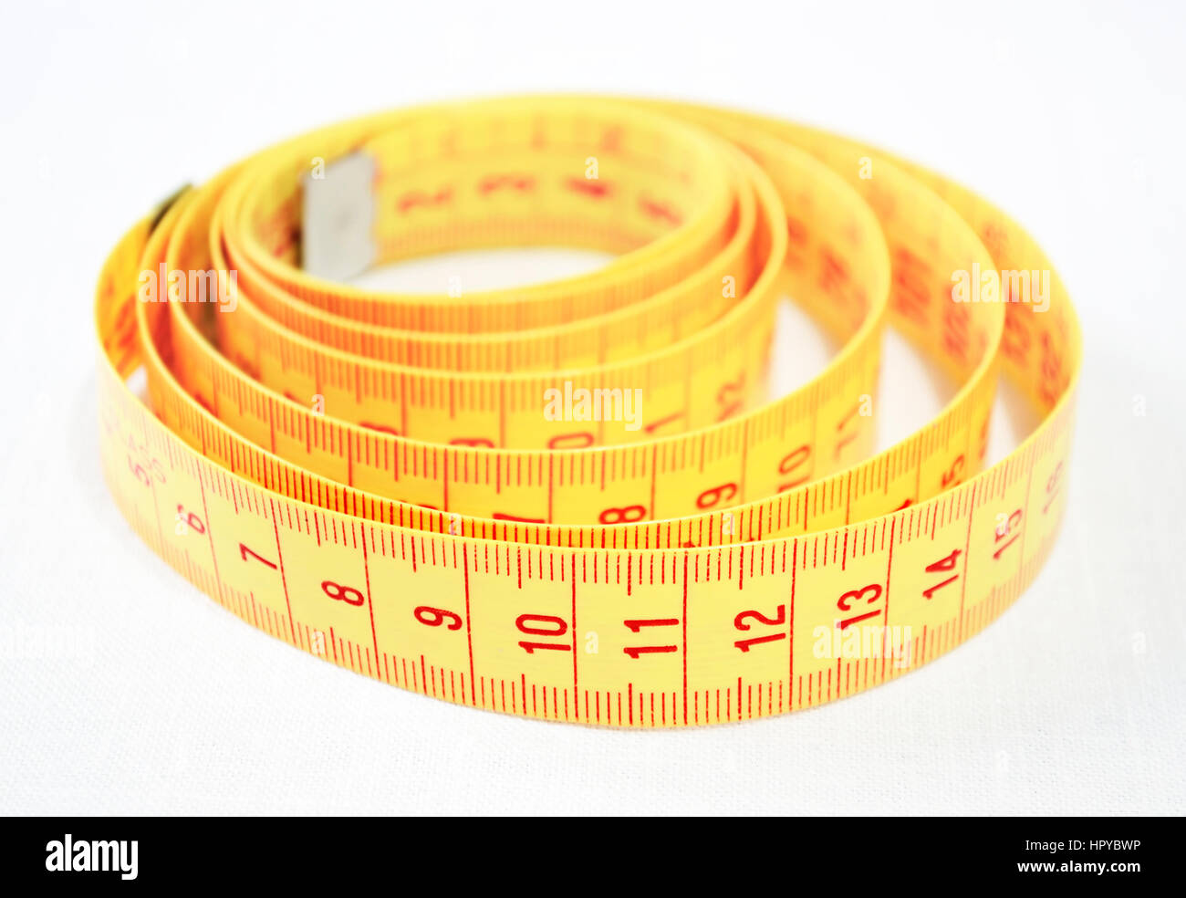 yellow tape measure on white background Stock Photo - Alamy
