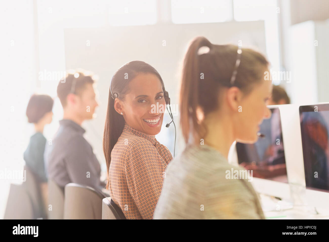 Portrait smiling female telemarketer wearing headset working at ...