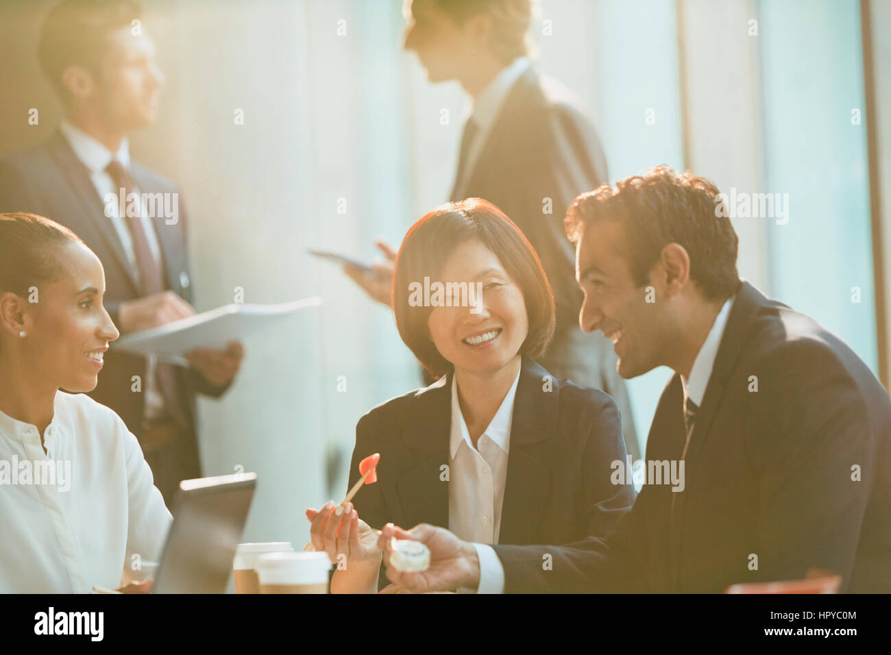 Business people eating lunch with chopsticks in conference room meeting ...