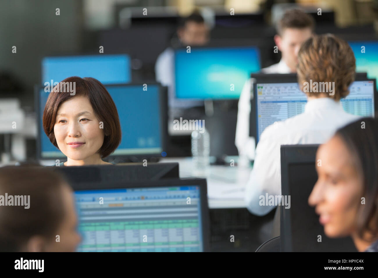 Businesswoman working at computer in open plan office Stock Photo - Alamy