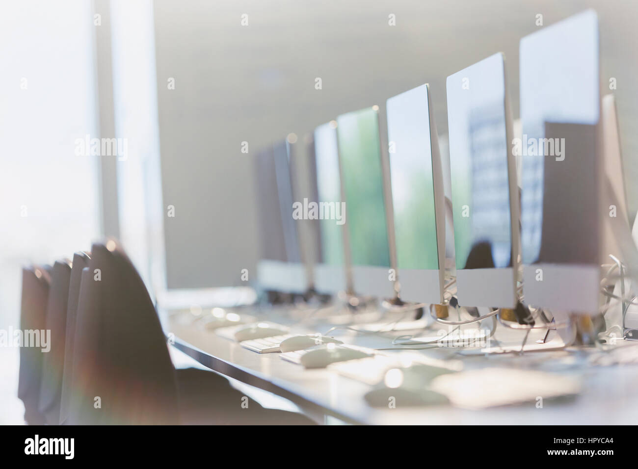 Computers in a row in office Stock Photo - Alamy