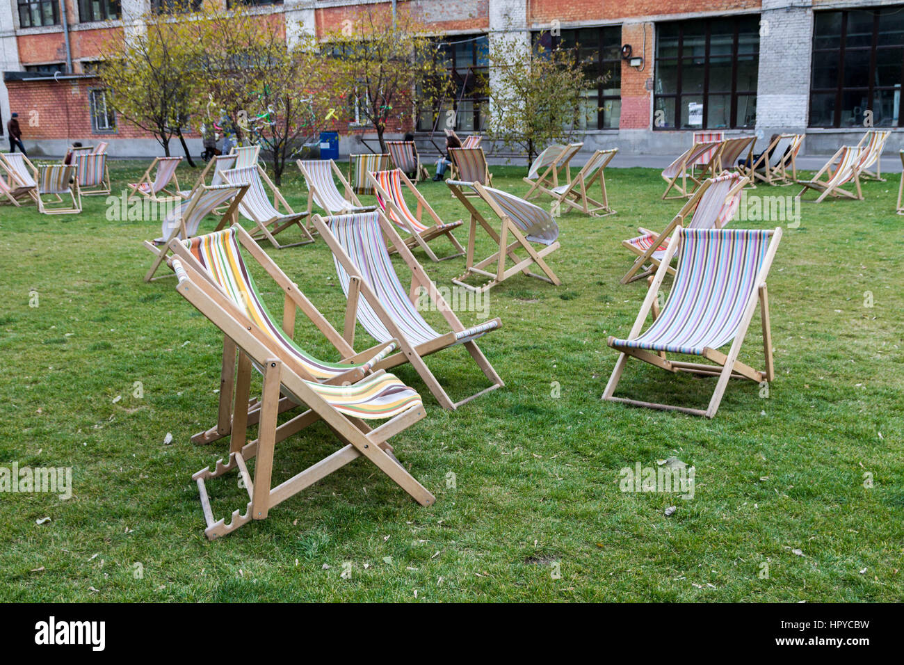 Sunbeds on the green lawn. Summer chair. Many summer chairs outside ...