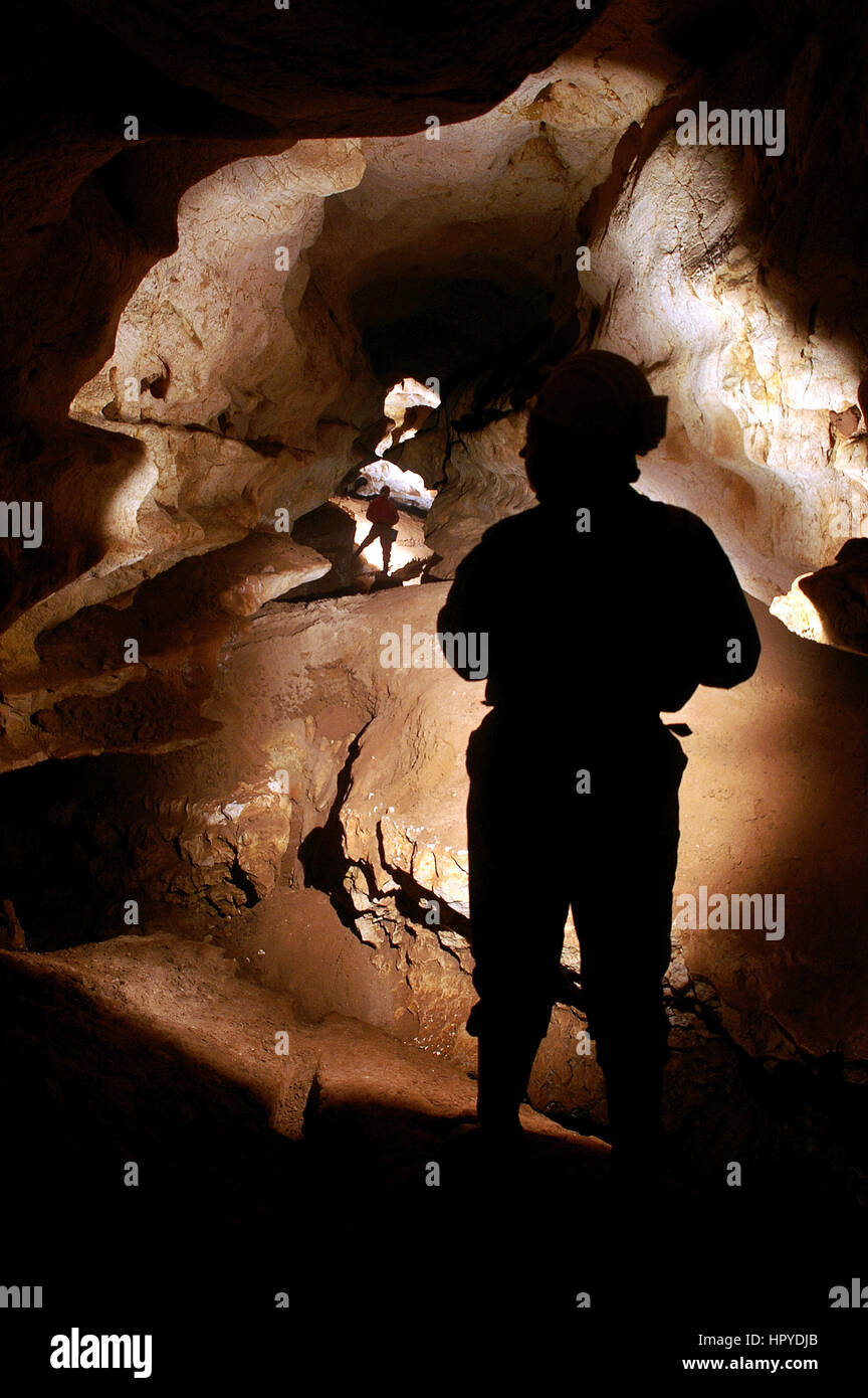 Spelunkers exploring a cave Stock Photo - Alamy