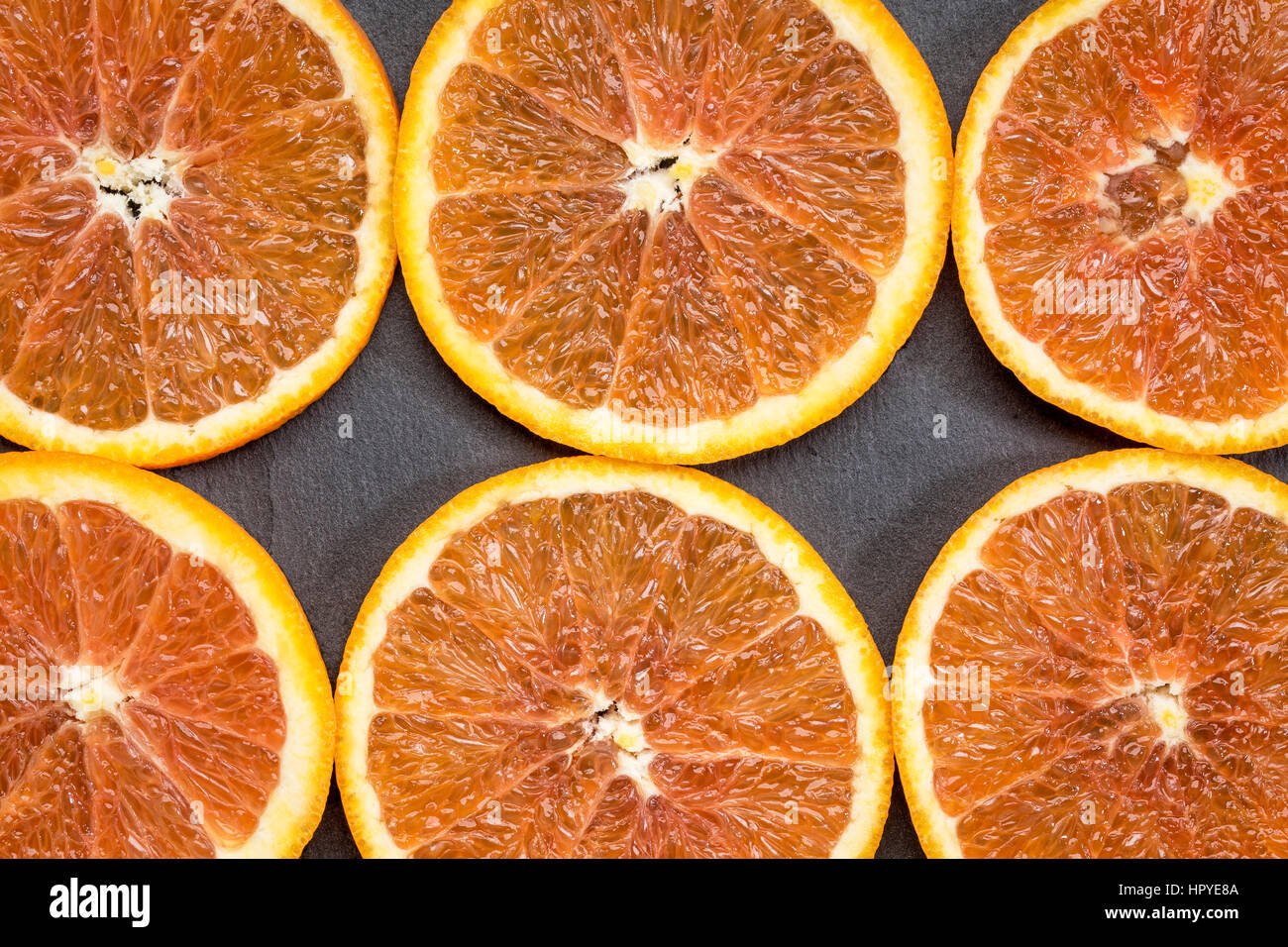 background and texture of fresh orange slices against gray slate stone ...