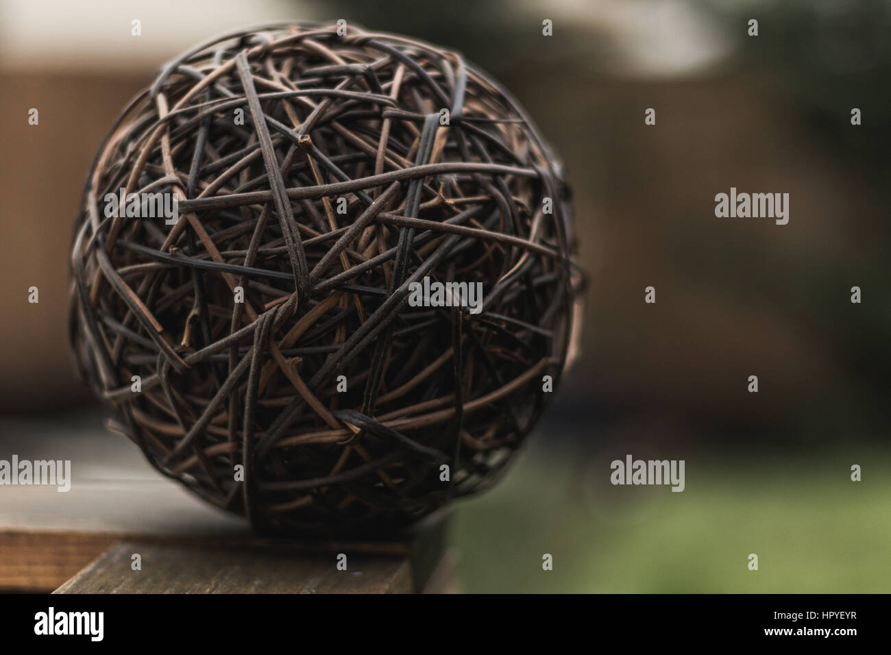 An isolated sphere made up of tangled wicker wood pieces. Meant as a ...
