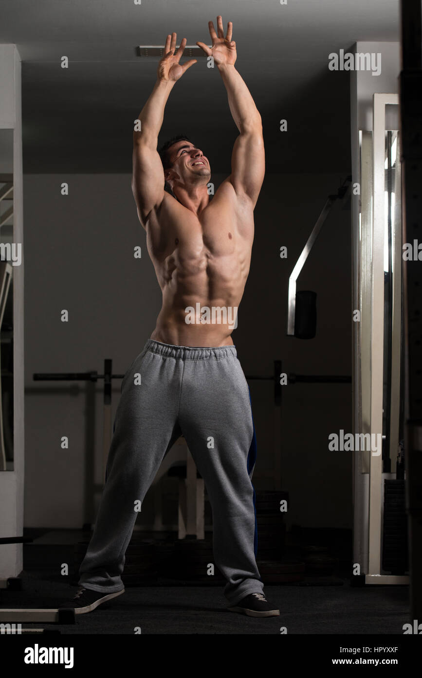 Handsome Man Standing Strong In The Gym And Flexing Muscles - Muscular ...