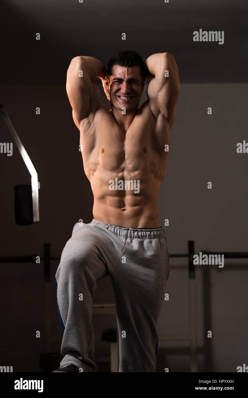 Young Man Standing Strong In The Gym And Flexing Muscles - Muscular ...