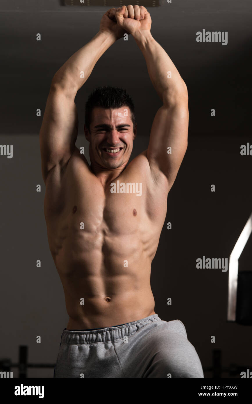 Young Man Standing Strong In The Gym And Flexing Muscles - Muscular ...