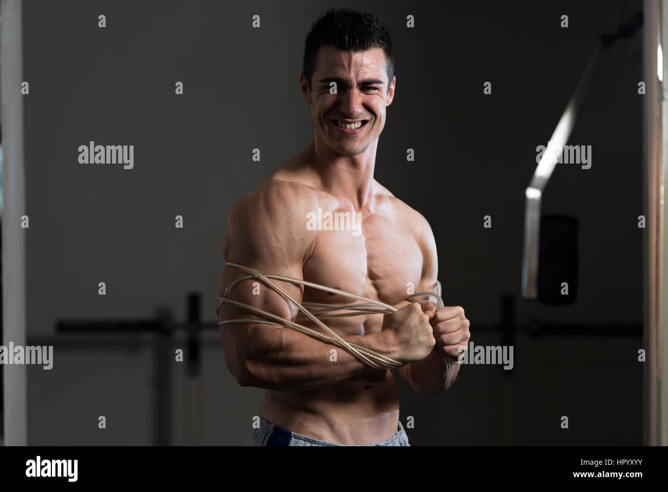Handsome Man Standing Strong In The Gym And Flexing Muscles With Cable ...