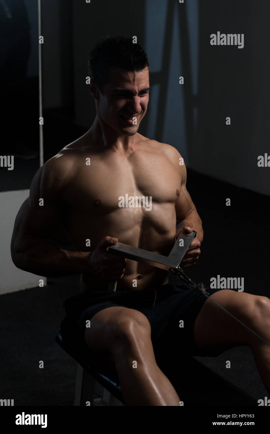 Strong Man In The Gym And Exercising Back On Machine - Muscular ...