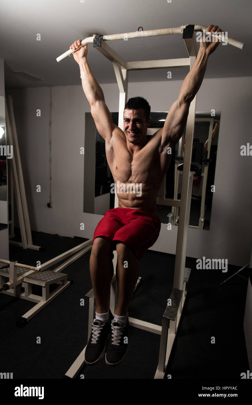 Young Man Performing Hanging Leg Raises Exercise - One Of The Most ...