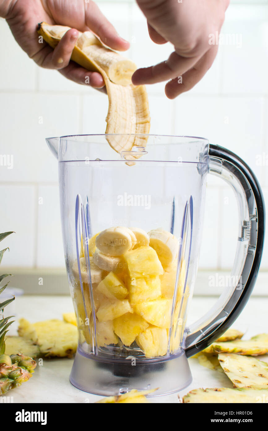 Hand adding banana slices into a blender Stock Photo - Alamy