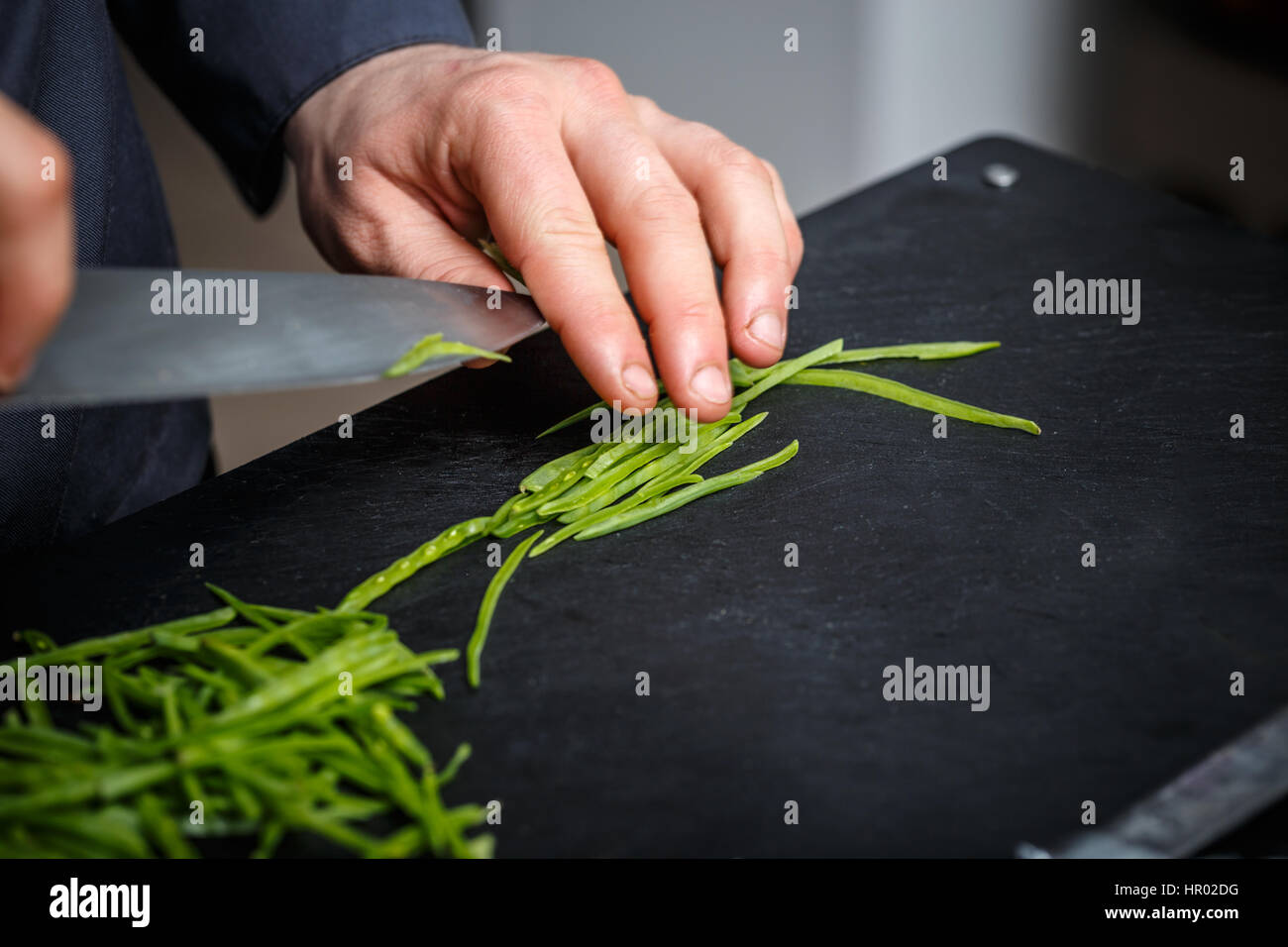 Chef cutting fresh green pea on the black cutting board Stock Photo - Alamy