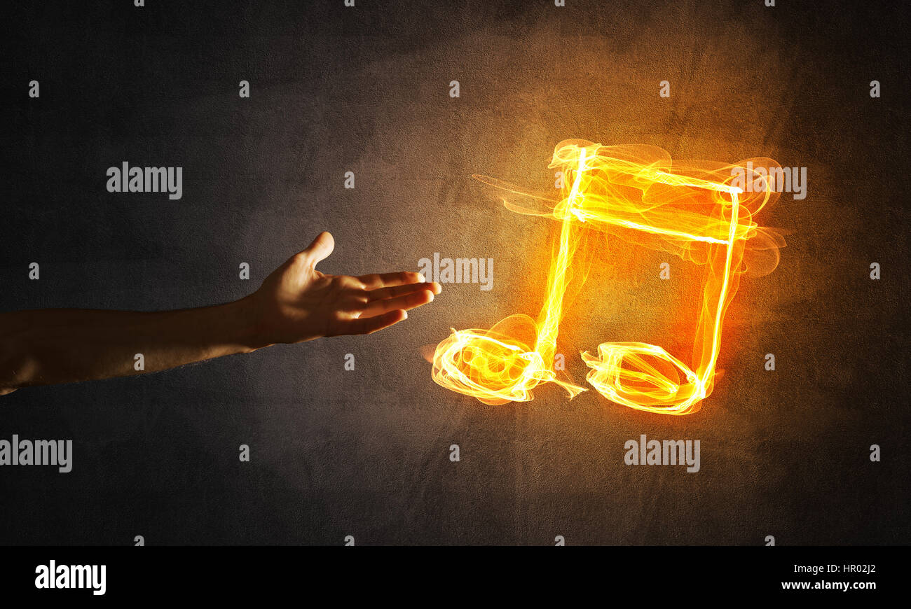 Close up of person hand and fire music symbol on dark background Stock ...