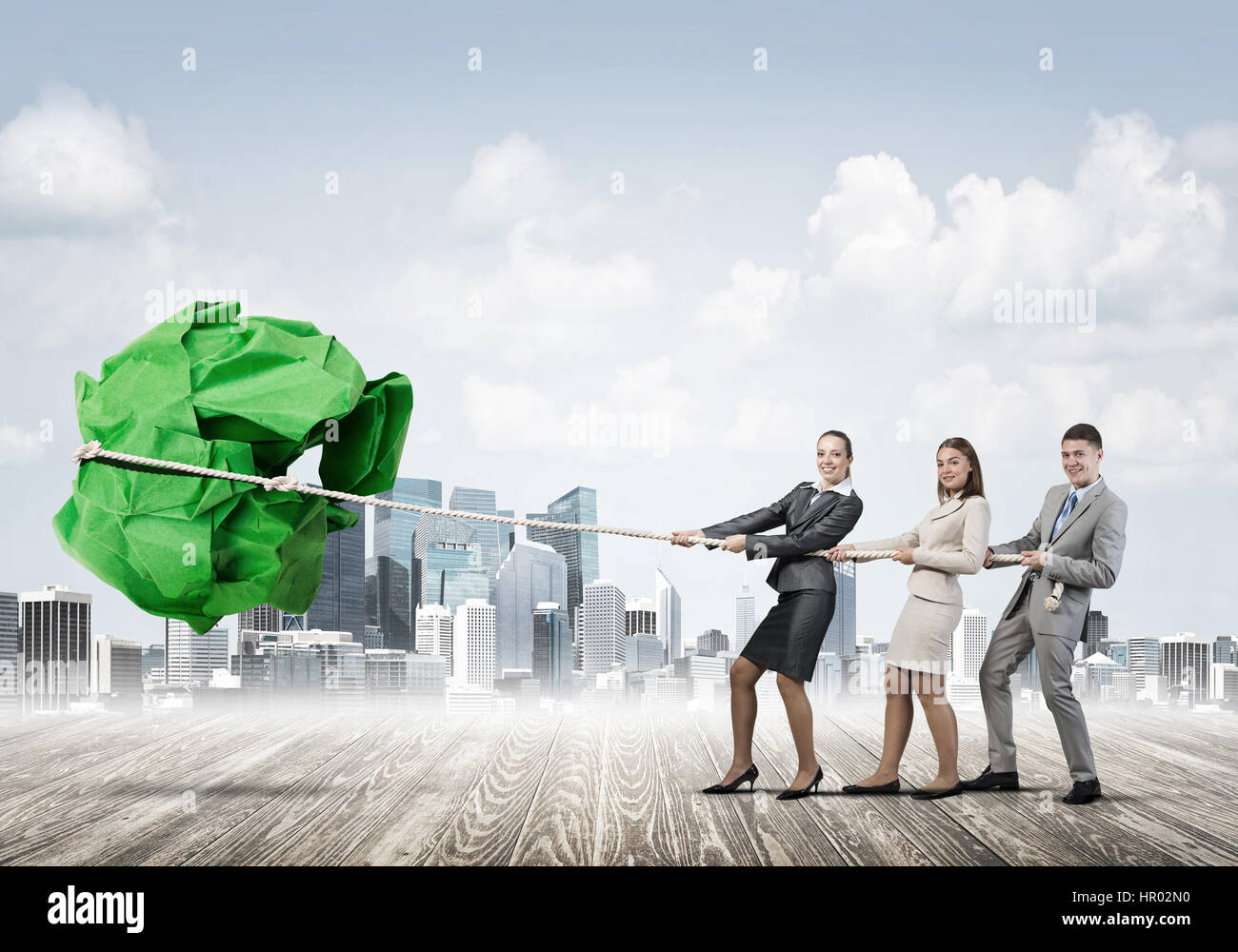 Office employees pulling together big crumpled paper ball Stock Photo ...