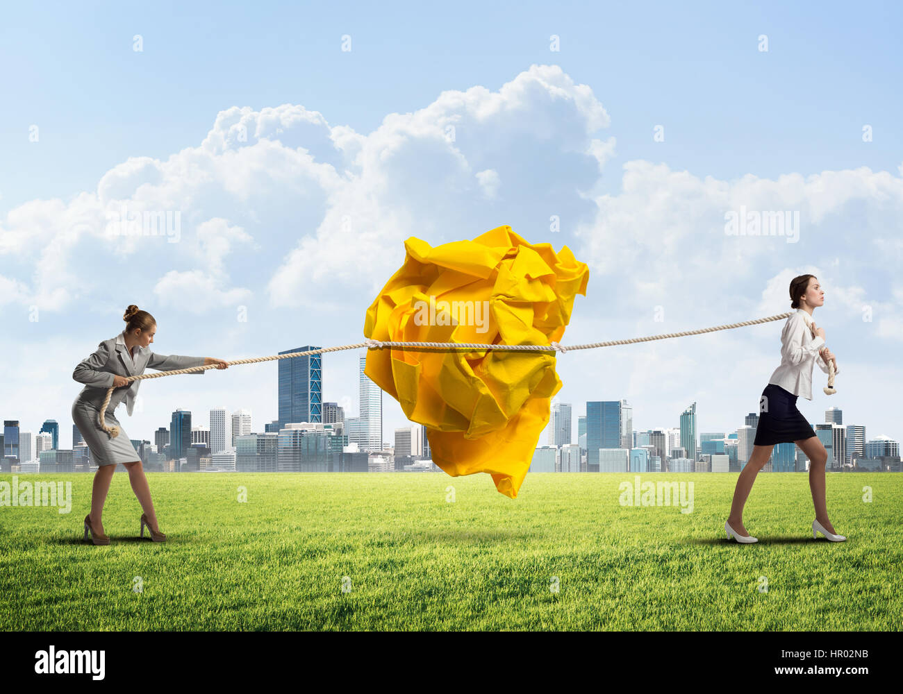 Two businesswomen outdoors playing tag of war game Stock Photo - Alamy