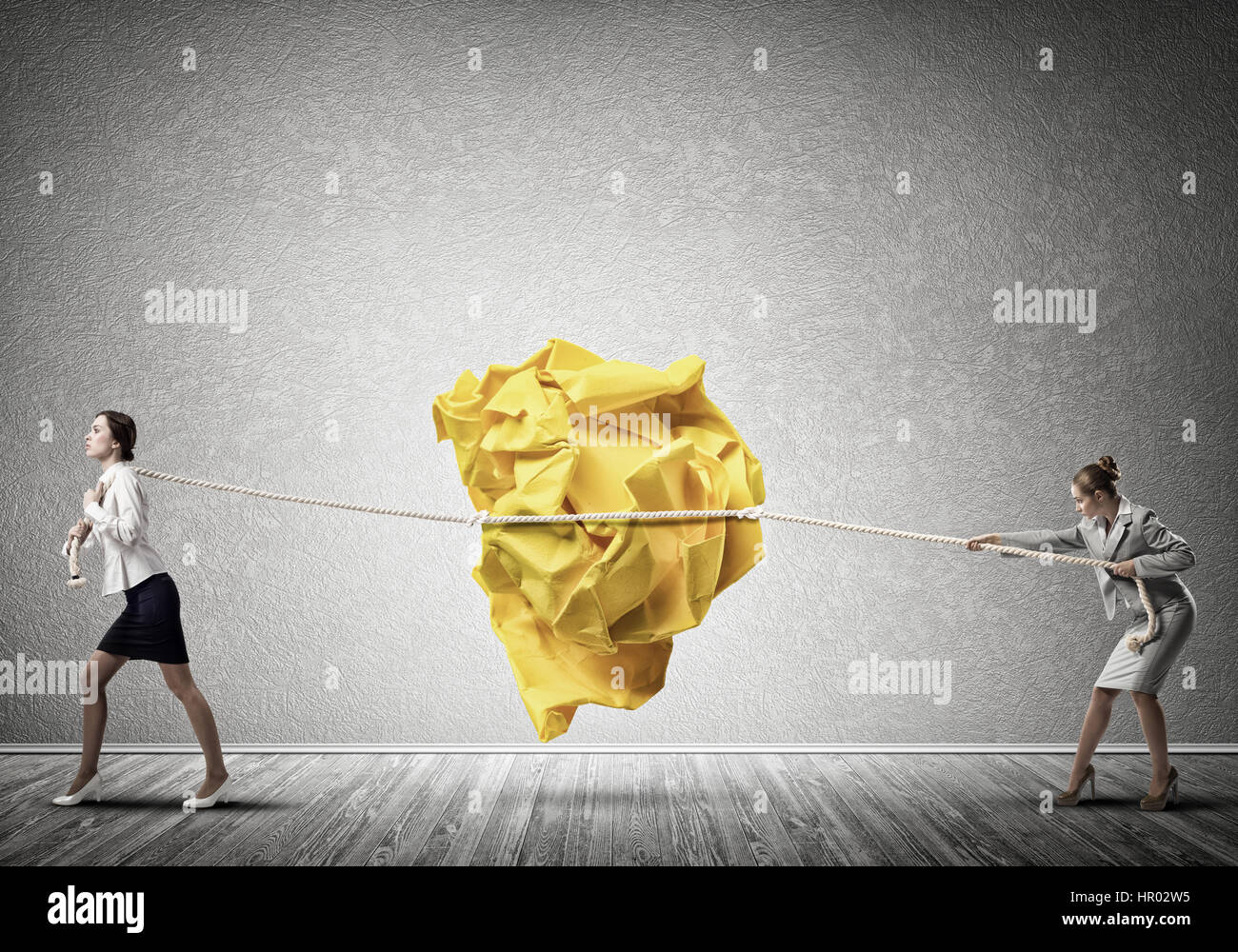 Two businesswomen playing tag of war game Stock Photo - Alamy