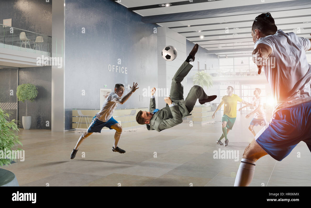Playing football in office . Mixed media Stock Photo - Alamy