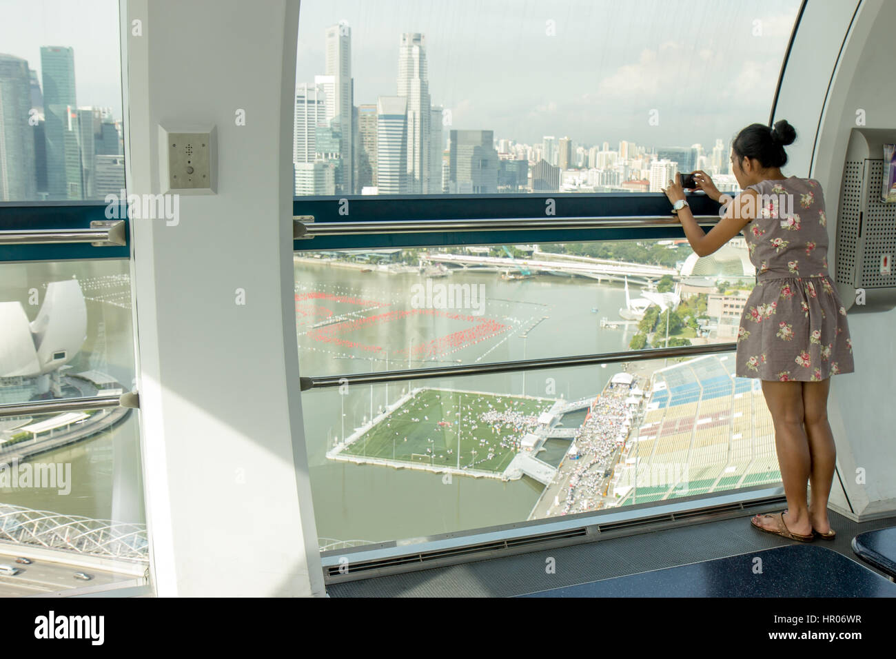 A woman looks over the city from the observation cabin. Girl ...