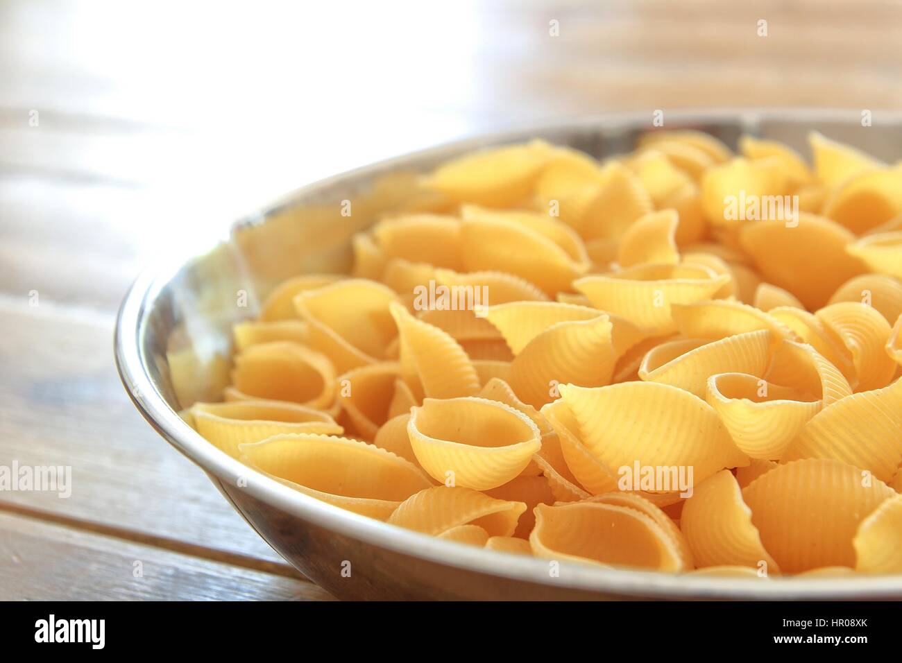 Dry conchiglie pasta shells in a stainless steel bowl Stock Photo - Alamy