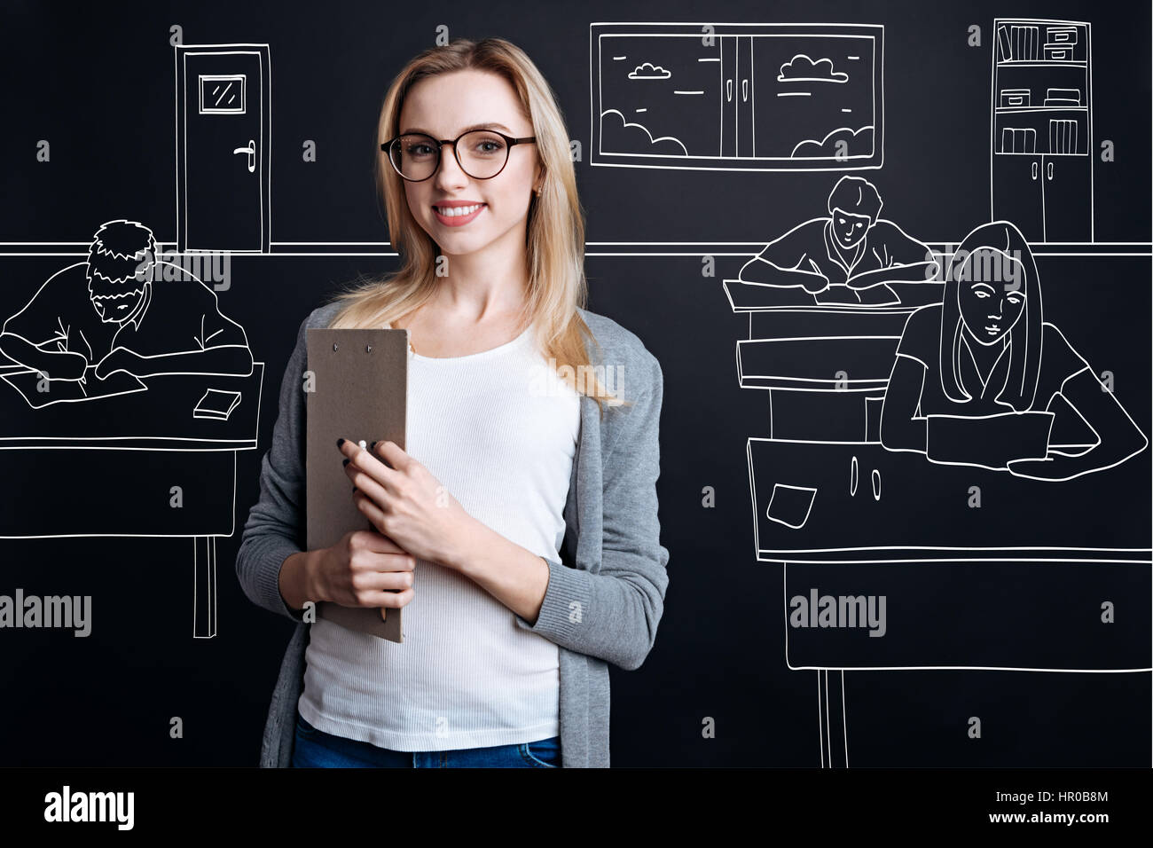 In the classroom. Happy nice intelligent teacher holding her notes and ...