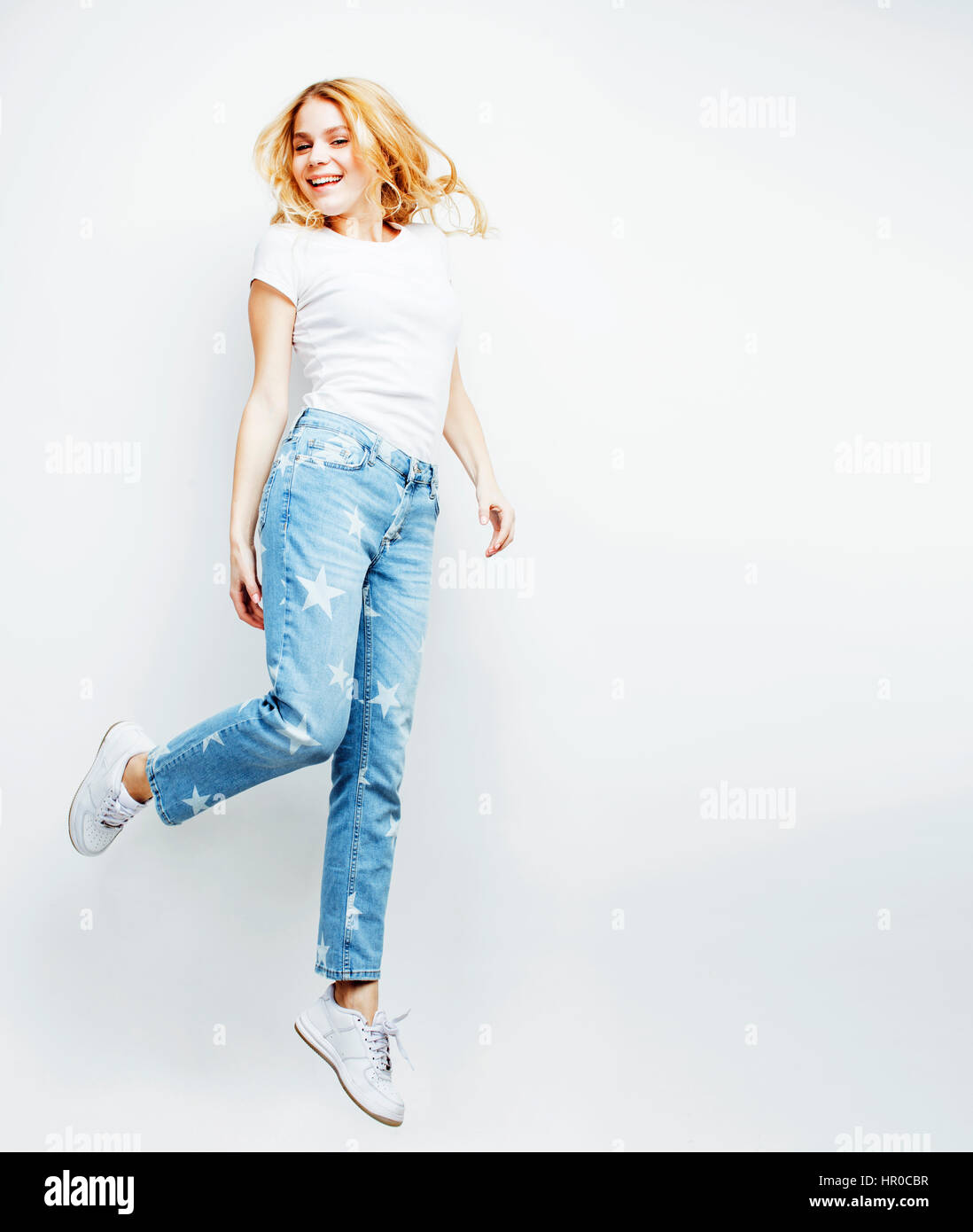 young pretty teenage girl jumping cheerful isolated on white background ...