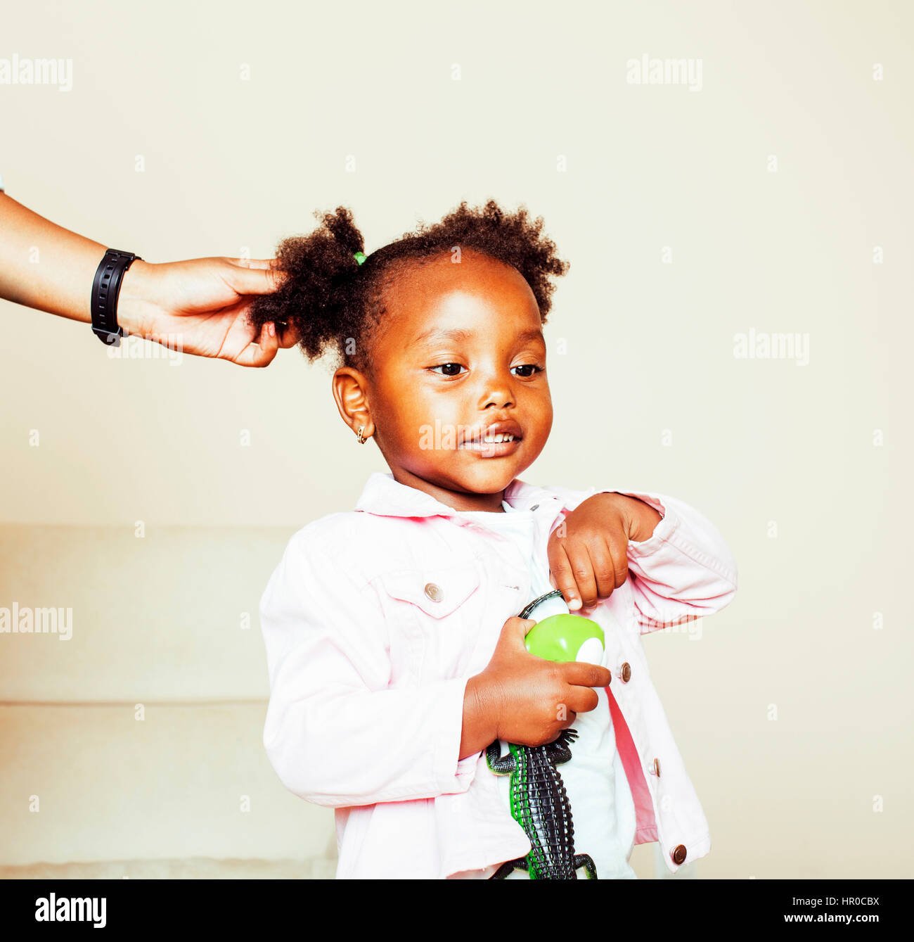 little cute sweet african-american girl playing happy with toys at home ...
