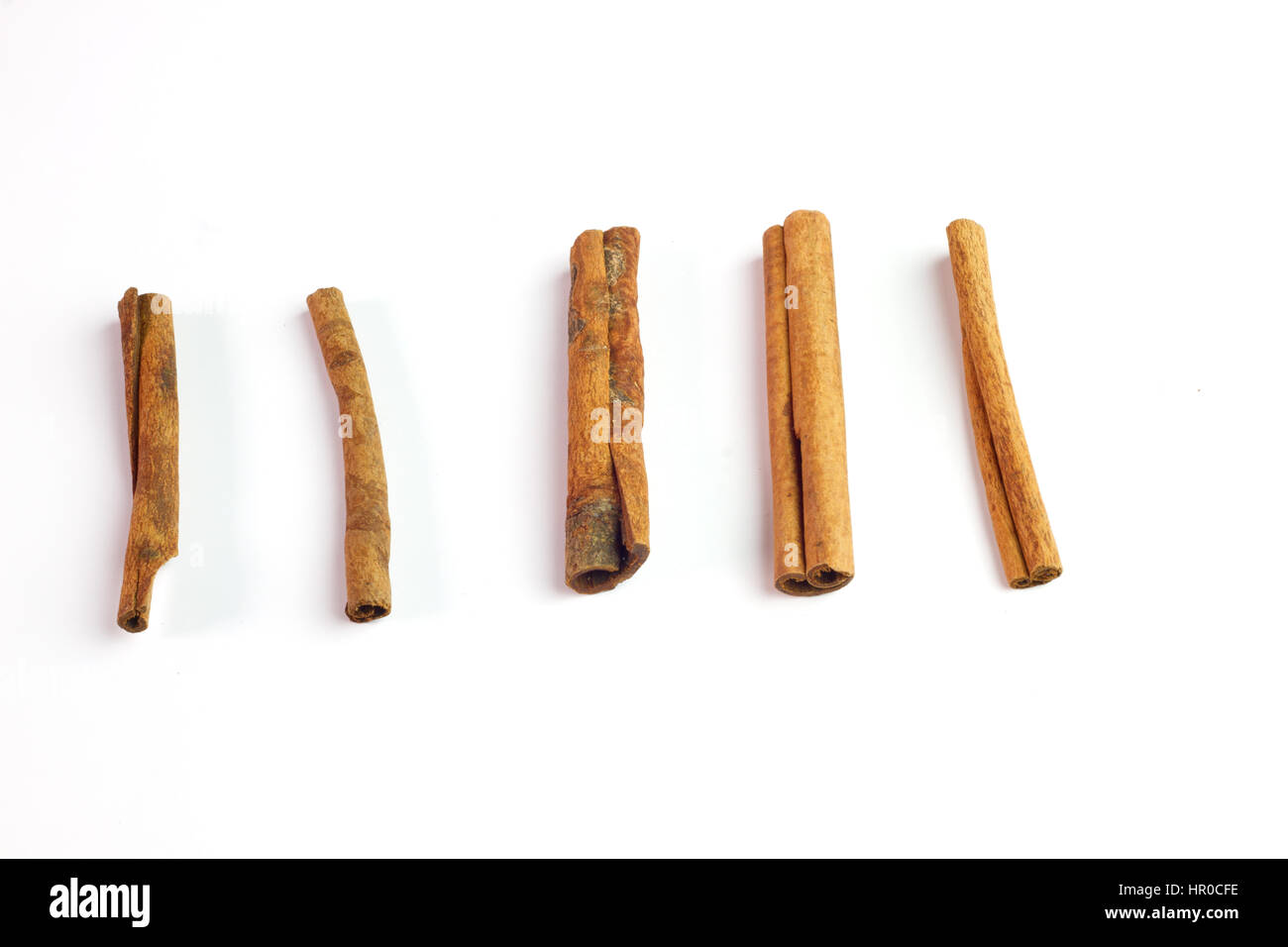 Row of cinnamon sticks isolated on a white background Stock Photo - Alamy