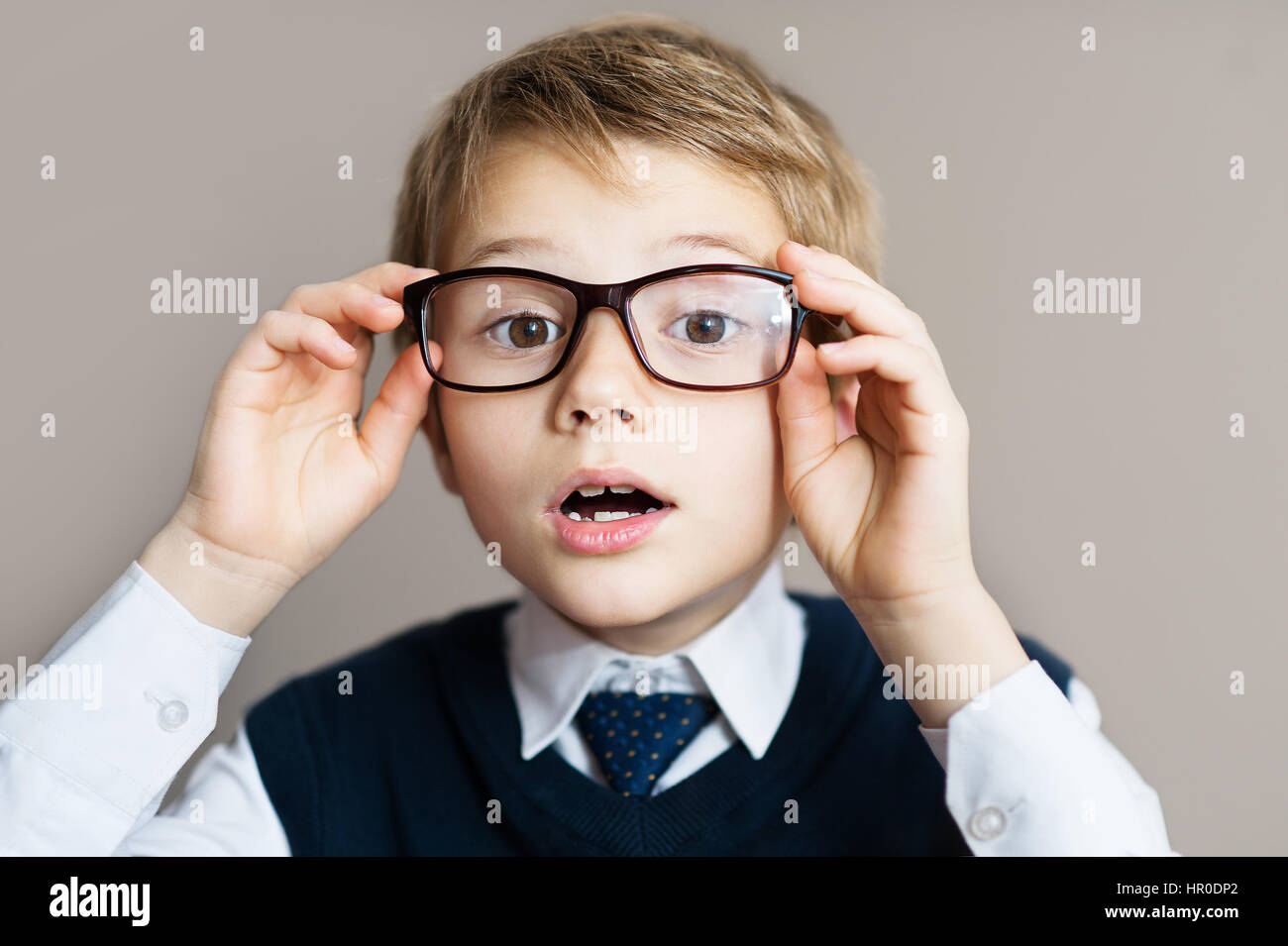 Little student boy in uniform on grey background Stock Photo - Alamy