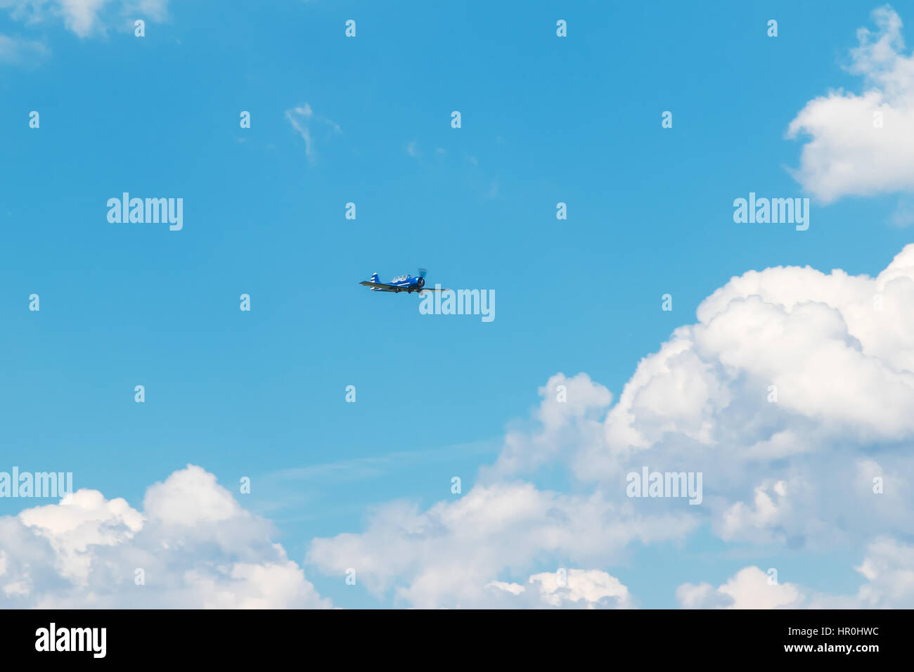 Blue striped plane with propeller flying in blue sky with clouds Stock ...