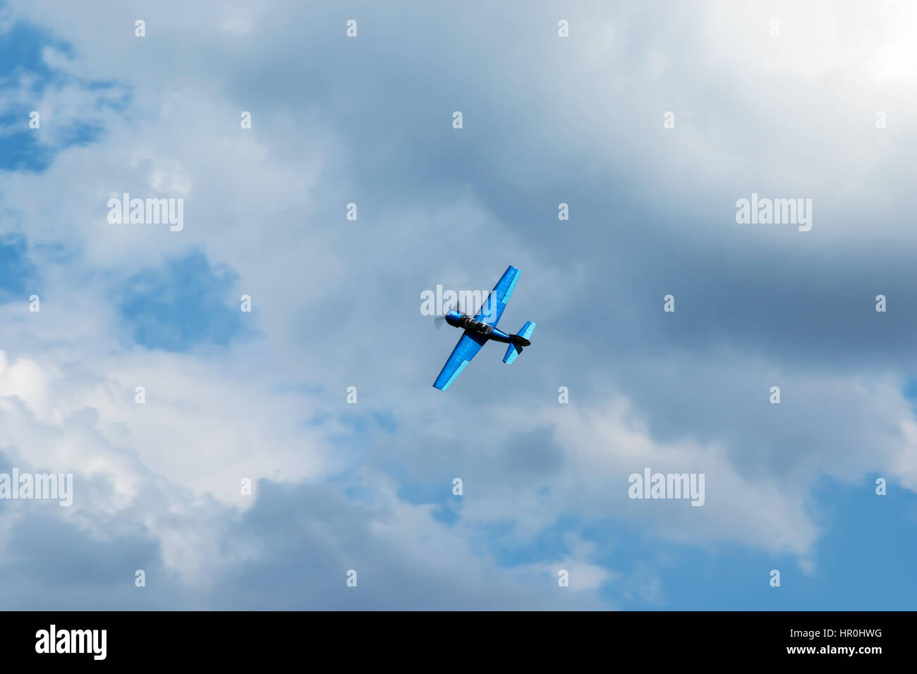 Blue sport propeller aircraft flying in the blue sky with clouds Stock ...