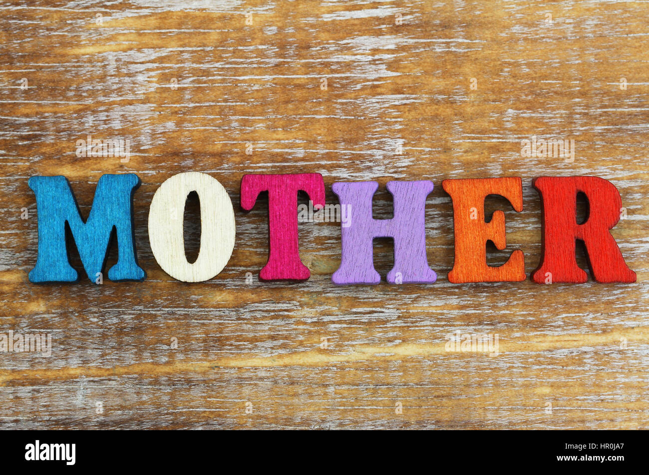Word mother written with colorful letters on rustic wooden surface ...