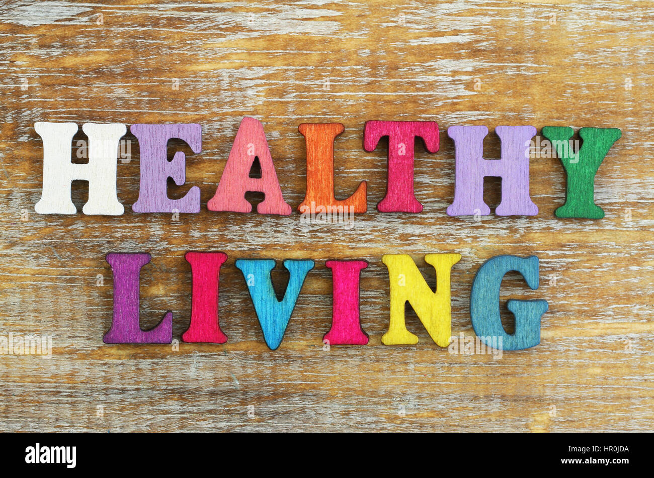 Healthy living written with colorful letters on rustic wooden surface ...