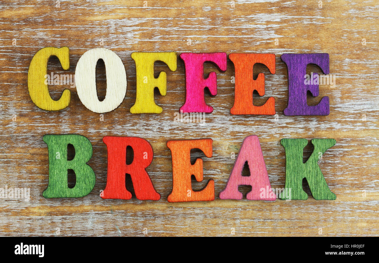 Coffee break written with colorful letters on rustic wooden surface ...