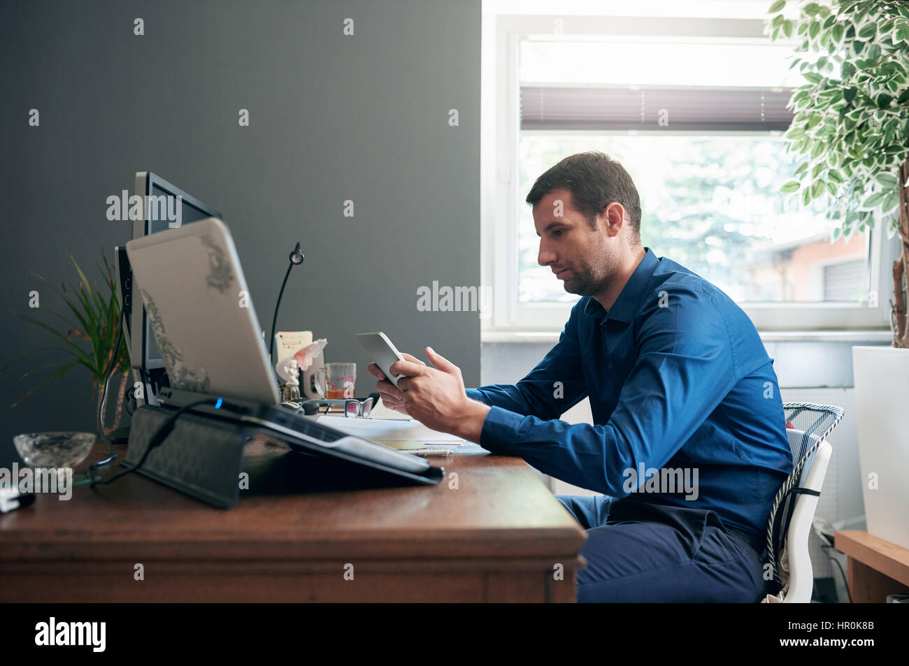 Confident and successful young businessman using a digital tablet while ...
