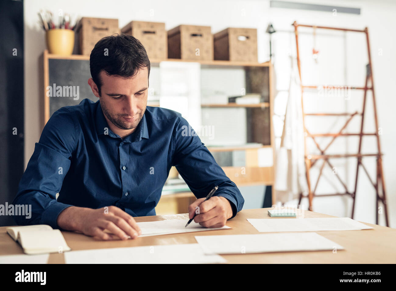 Confident and successful young businessman going through paperwork ...