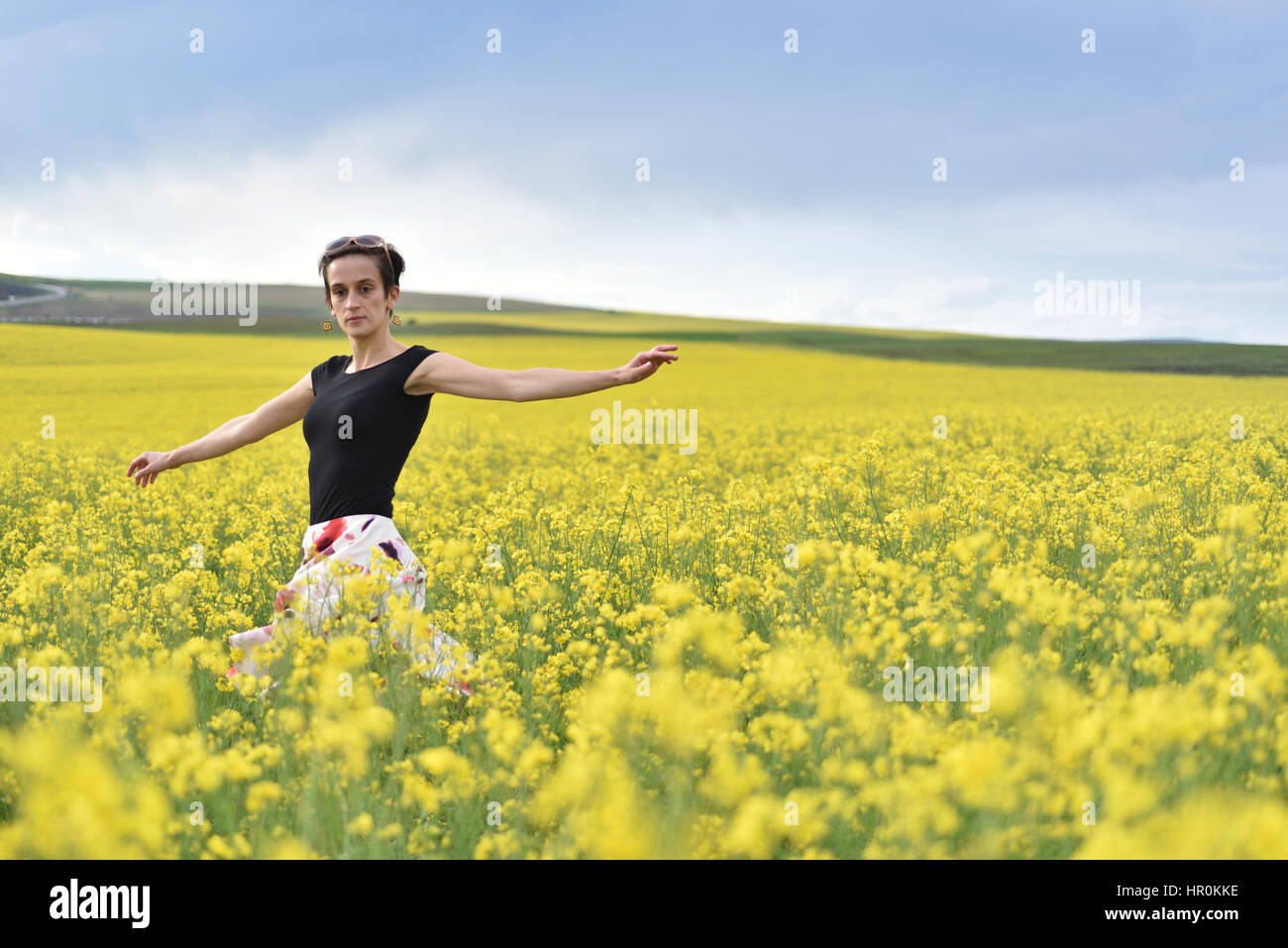 Happy woman cheering in canola field in the summer Stock Photo - Alamy