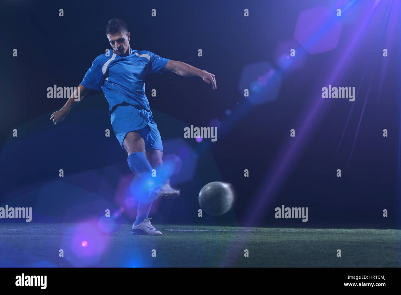 soccer player doing kick with ball on football stadium field isolated ...