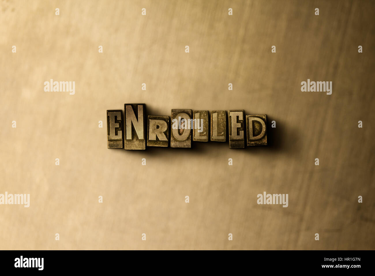 ENROLLED - close-up of grungy vintage typeset word on metal backdrop ...