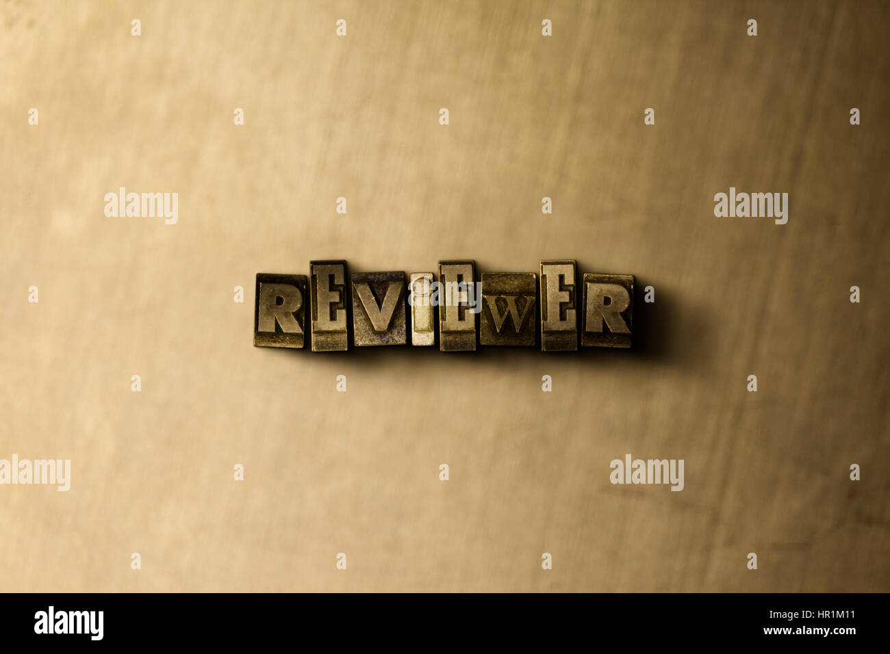 REVIEWER - close-up of grungy vintage typeset word on metal backdrop ...