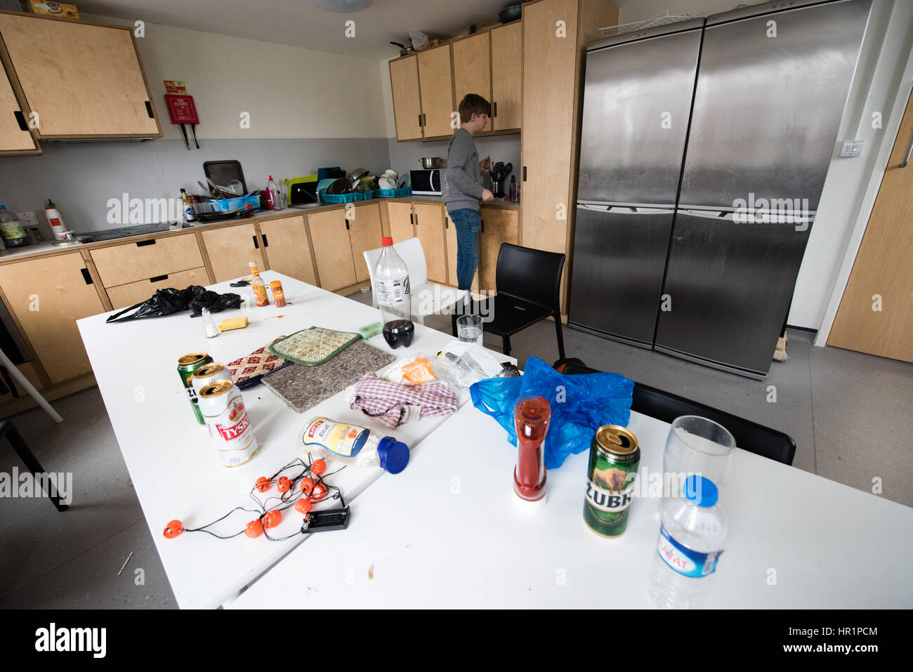 Dirty messy student shared kitchen with piles of washing up by the sink ...