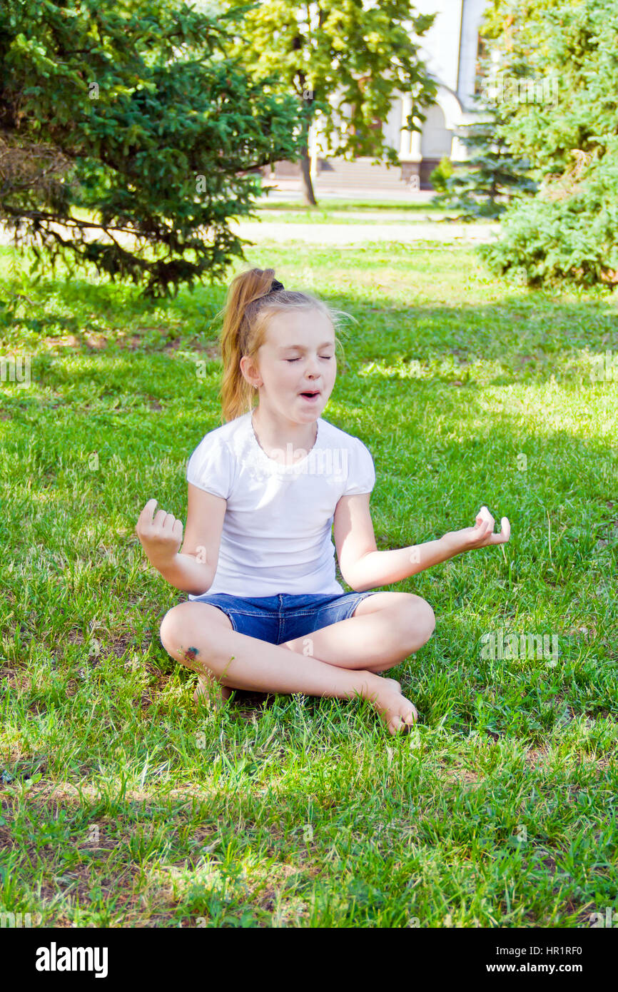 Photo of cute girl in lotus pose Stock Photo - Alamy